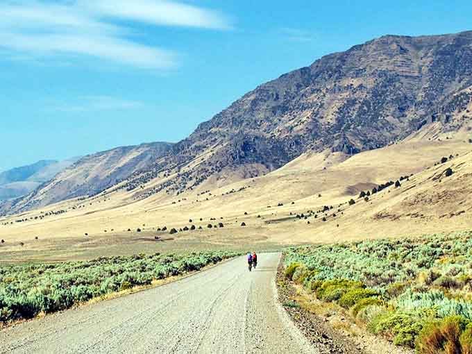 Two cyclists pedaling through high desert prove the best adventures require a little effort and spectacular mountain backdrops.