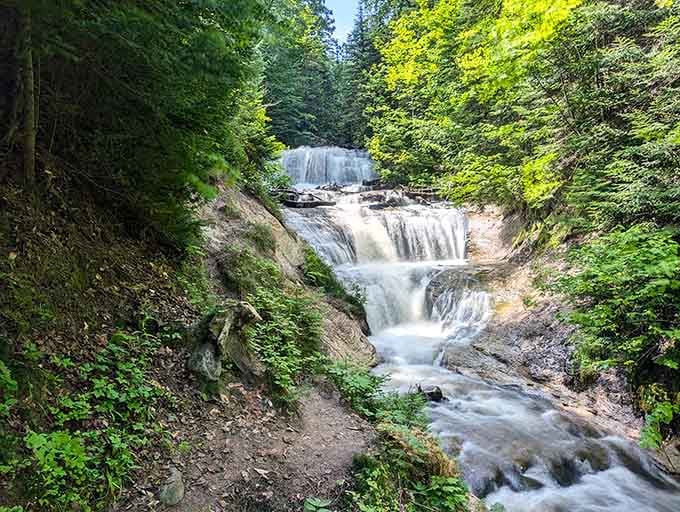 Multiple cascades tumble through the forest like nature's own staircase, each level more enchanting than the last.