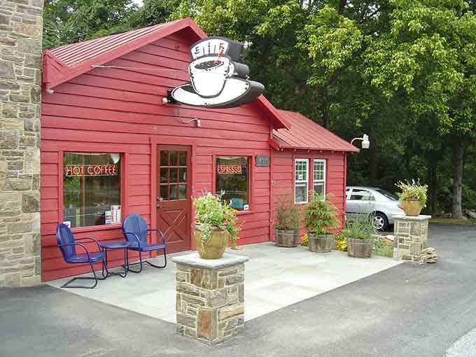 The barn-style doors and cozy patio make this red building feel like a countryside coffee retreat.