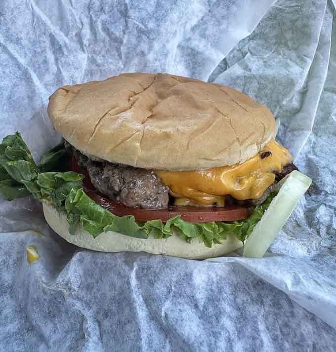 Behold the perfect cheeseburger: melted cheese draped over beef like a delicious yellow blanket of happiness.