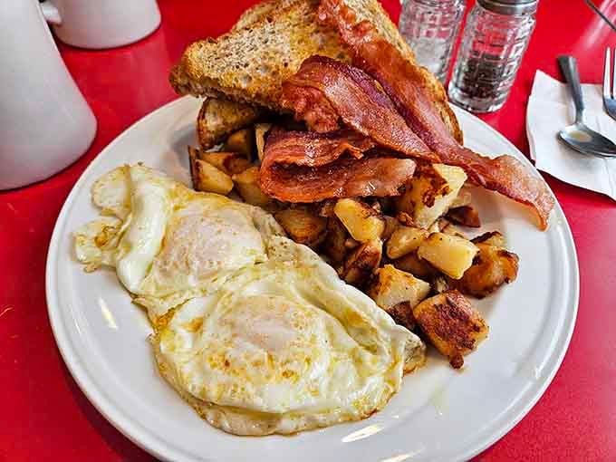 Eggs, bacon, toast, and potatoes arranged like they're posing for their high school yearbook photo.