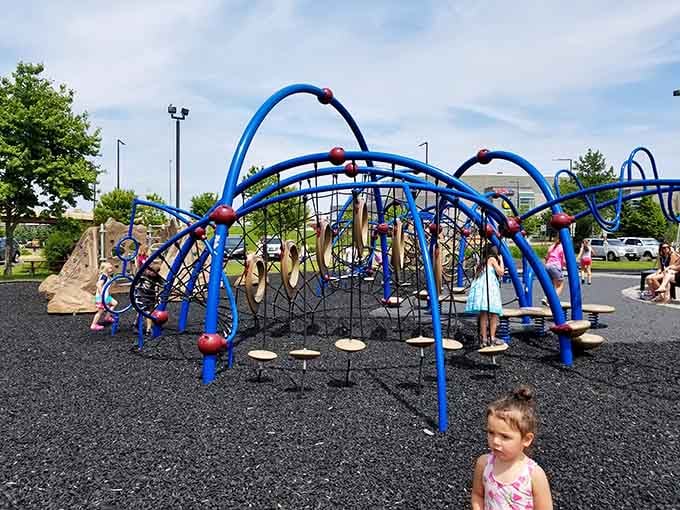 Kids conquer this blue climbing structure like tiny mountaineers tackling their own personal Everest playground.