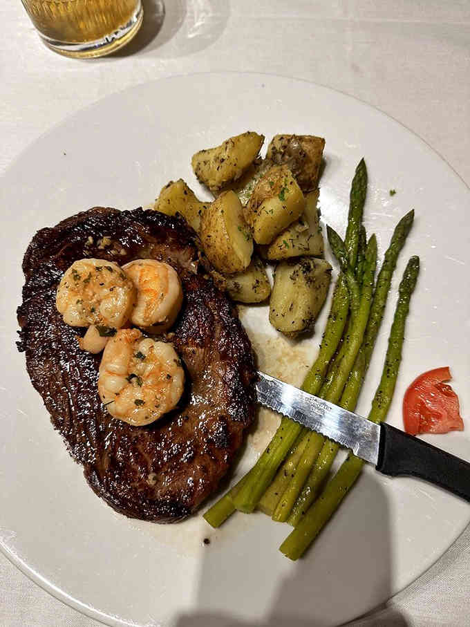 Steak topped with shrimp and served with roasted potatoes proves surf and turf never goes out of style.
