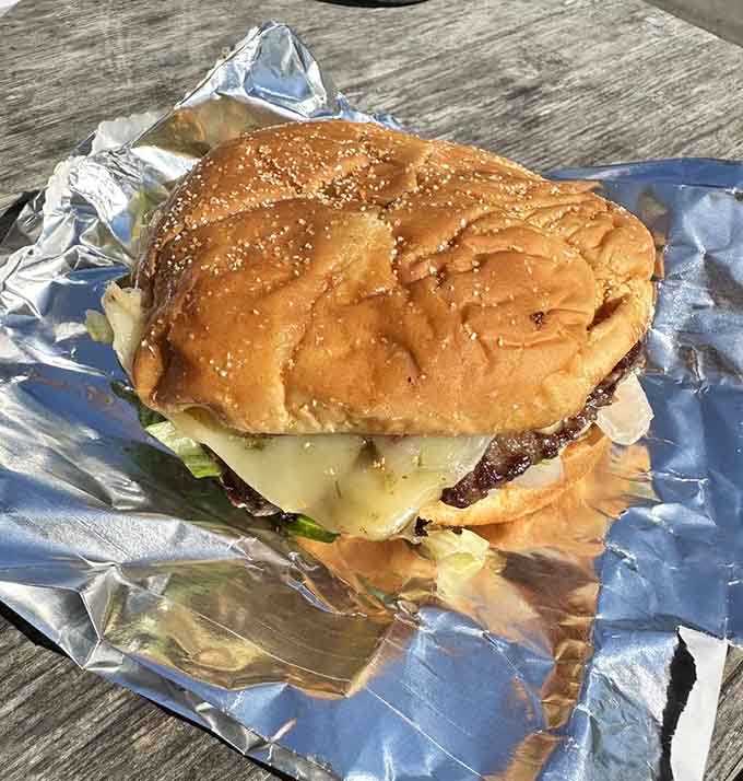 Golden sesame seeds crown this beauty, hiding layers of melted cheese and perfectly grilled beef waiting to be devoured.