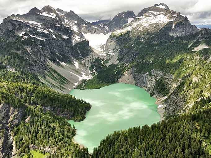 From above, the lake reveals its full glory, cradled between peaks like a precious turquoise gem.
