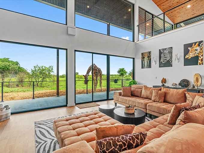 Two-story windows and leather seating create a space where comfort meets safari, like Out of Africa with better air conditioning.