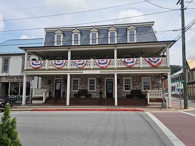 Those patriotic bunting decorations and wraparound porch whisper stories of hospitality that span generations, welcoming travelers since simpler times.