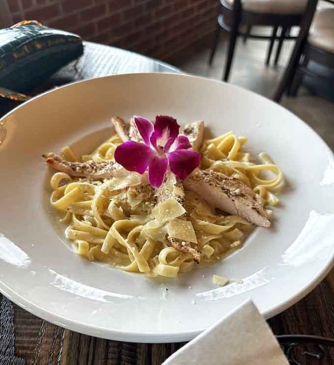 That delicate orchid perched atop creamy fettuccine is like finding a love letter in your pasta bowl, unexpected and delightful.