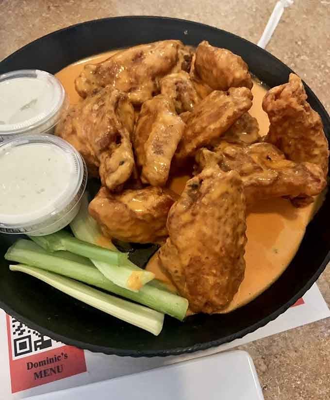 Fat Daddy wings arrive like golden treasures on a black plate, proving that sometimes the best names belong to the best food.