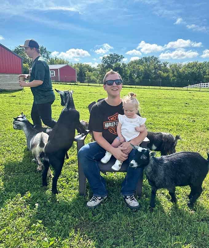 Three generations bonding over baby goats on a perfect Wisconsin afternoon under blue skies.