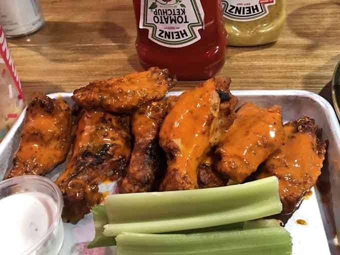 These wings arrive glistening with sauce, ready to fuel your game-watching marathon with sticky-fingered glory and celery sticks.