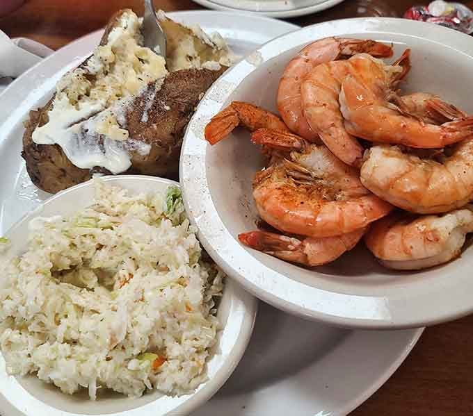 Perfectly seasoned shrimp alongside a loaded baked potato proves surf and turf works beautifully together.