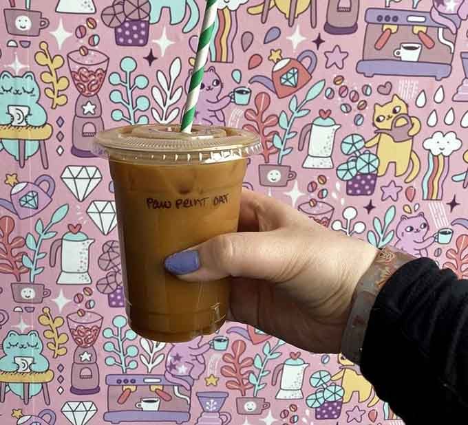The Paw Print Oat latte against whimsical wallpaper proves some drinks are almost too photogenic to actually consume.