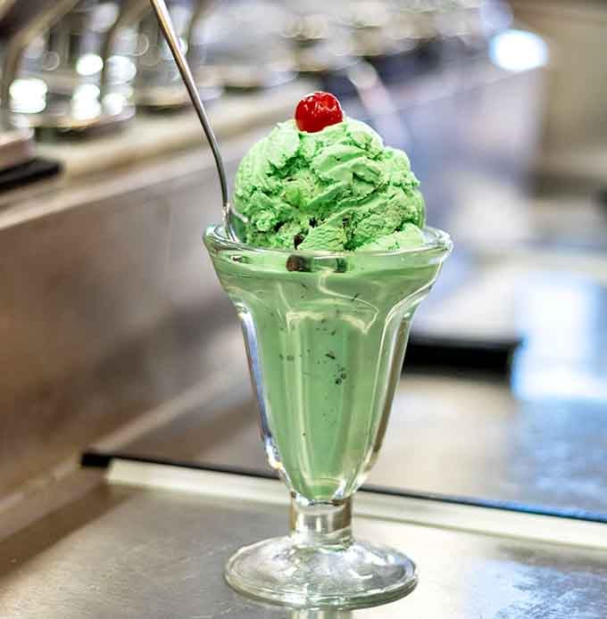Mint ice cream this vibrant green topped with a cherry is pure nostalgia served in a classic glass dish.