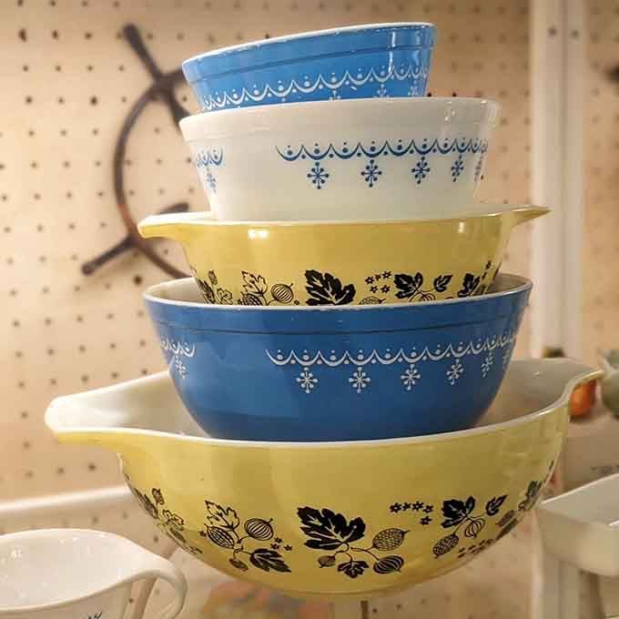Stacked Pyrex bowls in cheerful yellows and blues, ready to mix up some serious nostalgia.