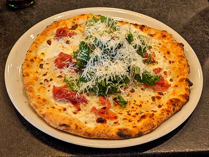 The Prosciutto pizza: where salty Italian ham meets peppery arugula and bright lemon in perfect harmony.