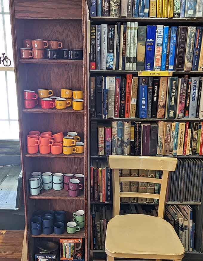 Colorful mugs nestled between books prove someone here gets that caffeine and reading are inseparable life partners.