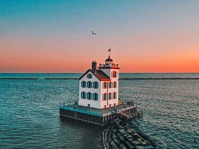 The Lorain Harbor Lighthouse stands sentinel at sunset, proving that some of life's most beautiful moments are absolutely free.