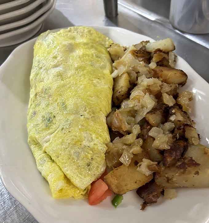That golden omelet fold is textbook perfect, paired with home fries that actually taste like someone's beloved grandmother made them.