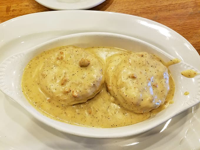 Two perfect biscuits swimming in creamy sausage gravy. This is what breakfast dreams look like.