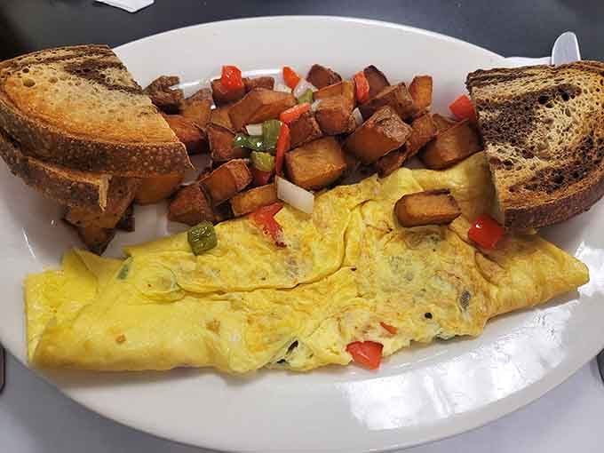 A fluffy omelet with perfectly seasoned home fries and toast, breakfast done the way it should be.