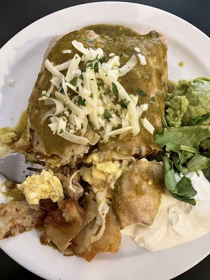 That breakfast burrito stands tall and proud, smothered in green chili like a proper Colorado morning should be.