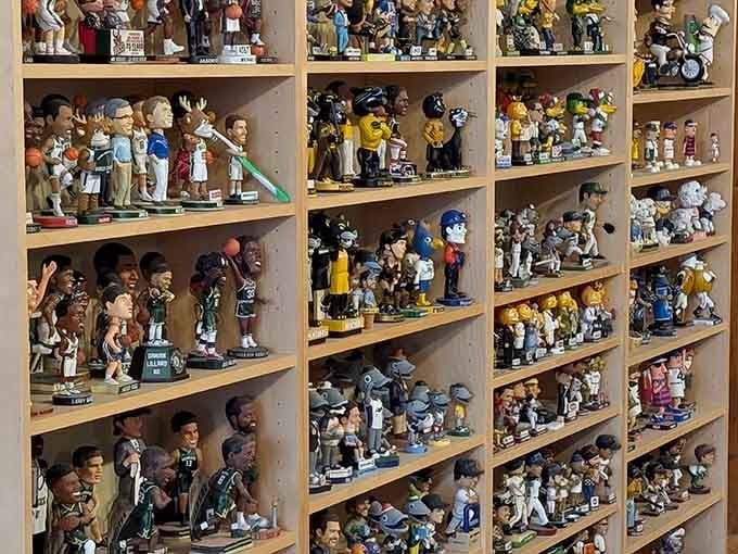 Sports legends and mascots share shelf space in perfect harmony, united by their oversized heads and enthusiastic bobbling capabilities.