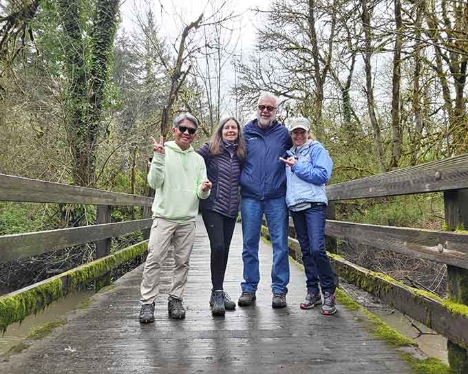 Four happy visitors proving that the best family photos happen on bridges surrounded by moss and good vibes.