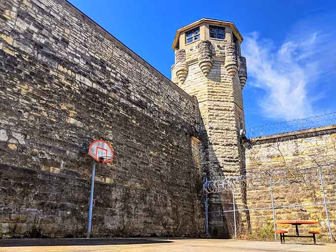 Even the basketball hoop looks lonely against those towering walls, a reminder that recreation time had very definite boundaries here.