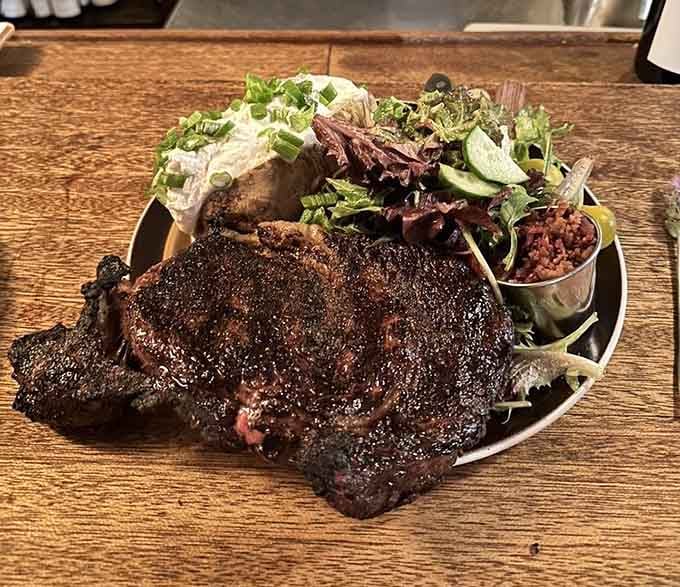 That char-grilled ribeye with loaded potato proves fire and meat remain humanity's greatest culinary partnership.
