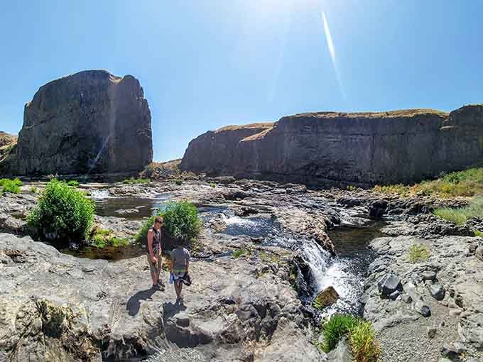 Explorers dwarfed by towering rock formations, proving that nature always wins the size competition around here.