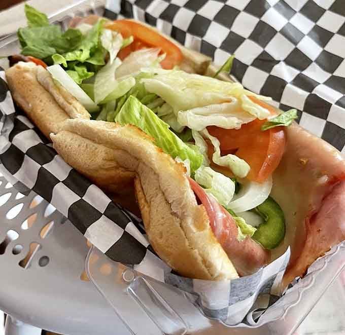 This loaded hot dog brings lettuce, tomato, and pickles to a bun that's clearly living its best life.