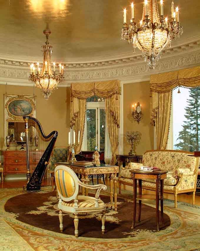 Crystal chandeliers and a harp create the kind of elegance that makes modern living rooms look like storage units.