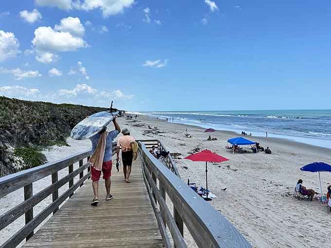Wooden boardwalks lead beachgoers over protected dunes, making the journey part of the destination itself.