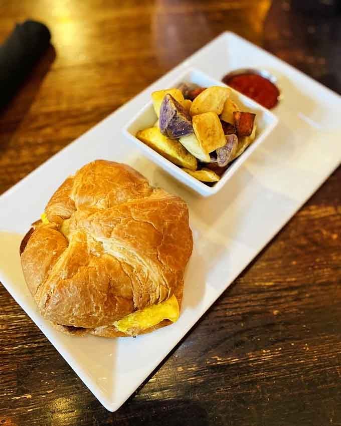 That flaky croissant breakfast sandwich with roasted potatoes proves morning carbs are always worth it, no matter what your fitness tracker says.