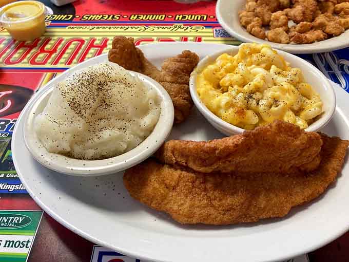Golden fried fish with creamy mashed potatoes and mac and cheese, the holy trinity of Southern comfort on one plate.