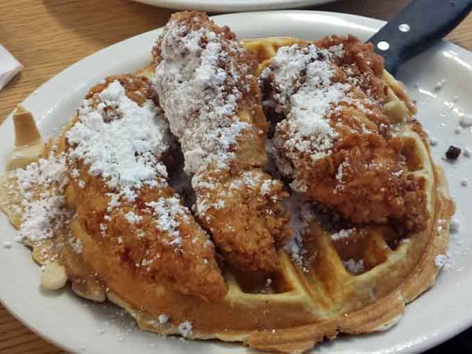 Chicken and waffles dusted with powdered sugar, because sometimes breakfast needs to wear its Sunday best.