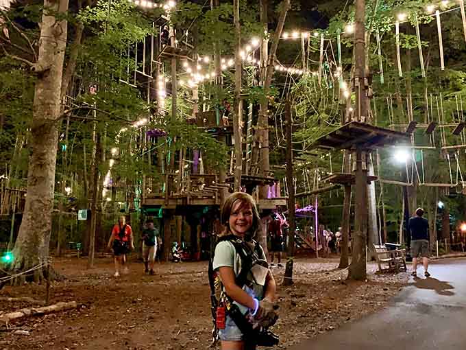 Ready for takeoff! This visitor's smile says everything about the magic waiting in Virginia Beach's illuminated forest canopy.