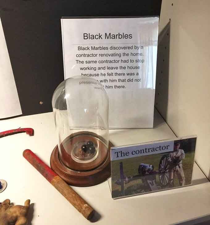 Black marbles under glass with a backstory about a contractor who noped right out of renovations, smart man indeed.