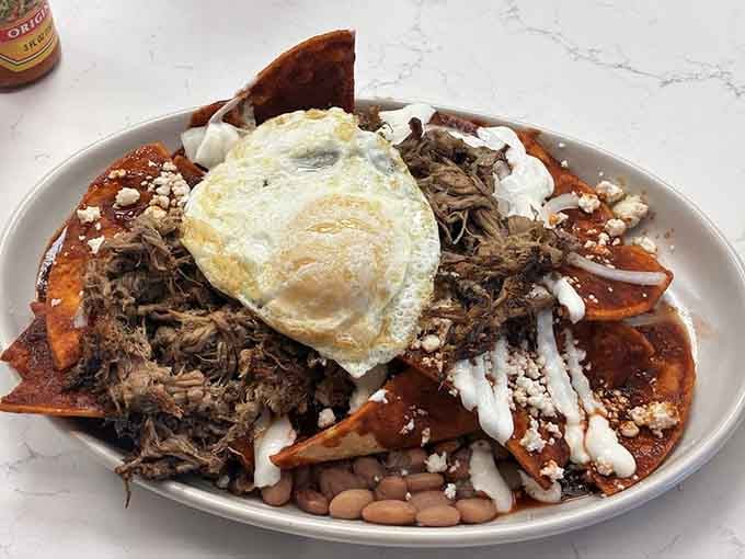 Chilaquiles topped with perfectly cooked eggs and tender meat, because comfort food should actually be comforting, not apologetic.