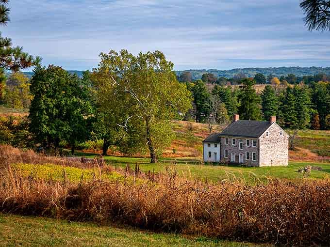 This stone house nestled among autumn colors stands as a testament to colonial architecture and Revolutionary War resilience.