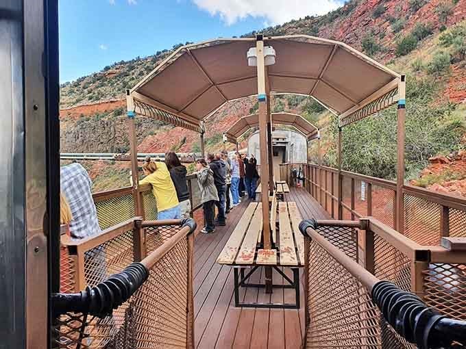 The open-air viewing car lets you feel the canyon breeze while towering red rocks pass overhead.