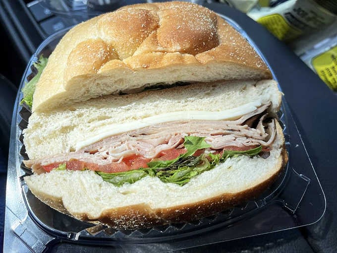 Look at that towering masterpiece on a braided roll, proof that some sandwiches are built for serious hunger.
