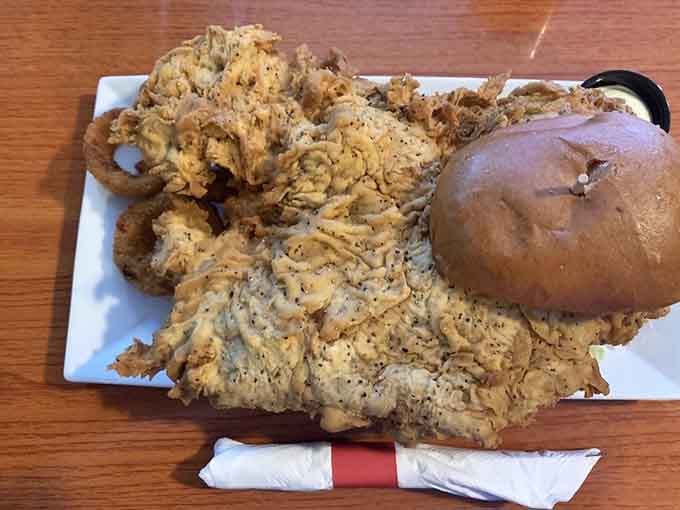 Behold the tenderloin that launched a thousand napkins, sprawling across the plate like edible performance art.