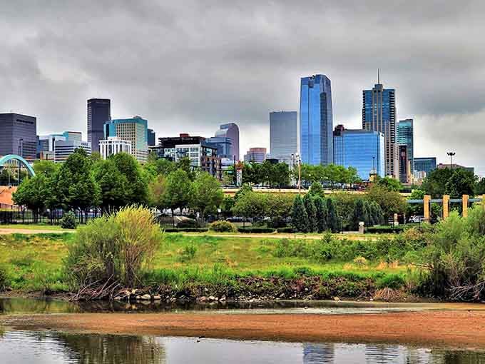 Storm clouds gather over the Mile High City skyline while the South Platte River rolls peacefully below.