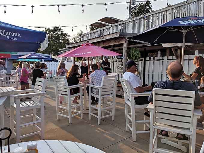 White Adirondack chairs and string lights transform this outdoor space into a breezy paradise for seafood and good conversation.