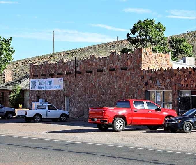 Desert stone walls stand strong against the elements, sheltering travelers in this remote outpost where the road stretches endlessly onward.