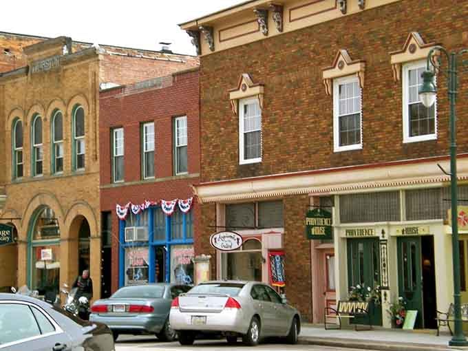 Patriotic bunting decorates storefronts that have weathered decades, each one telling stories through their weathered facades.