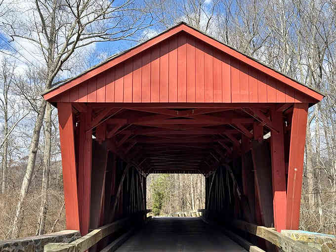 Winter reveals this bridge's elegant bones, standing proud above the babbling creek like a patient guardian through the seasons.