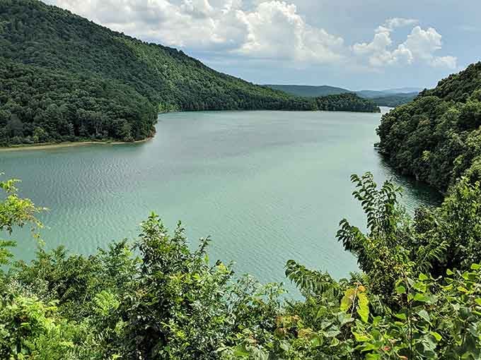 Mountains embrace this jade-green lake like protective arms, creating a hidden valley that feels wonderfully remote.
